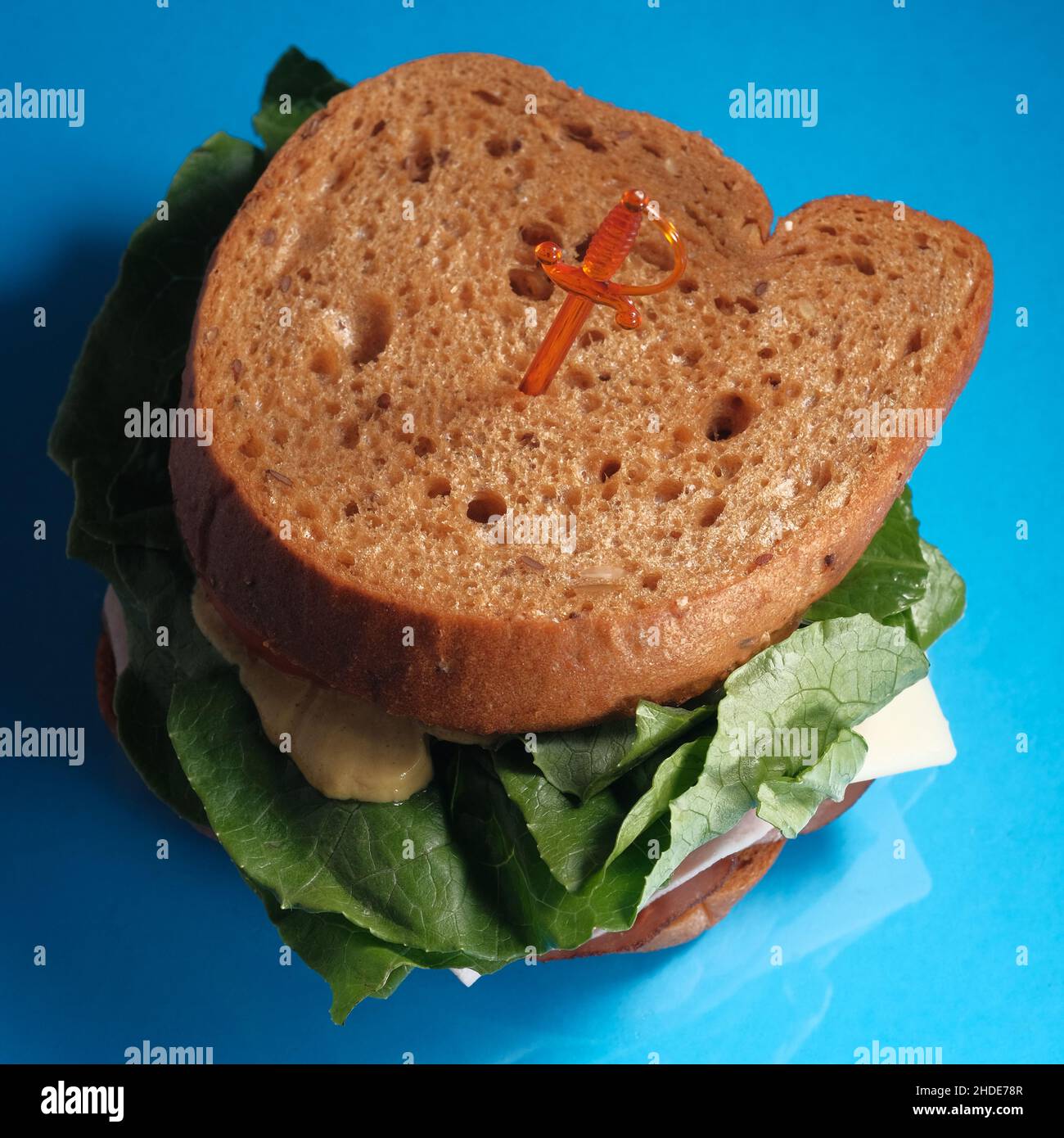 Ham and roast beef sandwich with American cheese and a cocktail sword ...