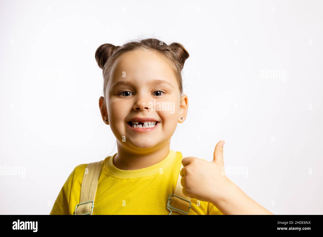 Portrait of shining little girl showing missing front baby tooth and ...