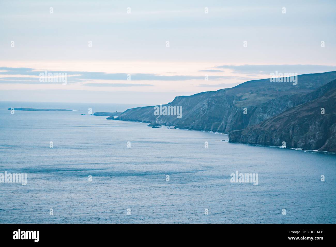 Scenic view of a calm coast and mountainous island at sunset Stock ...