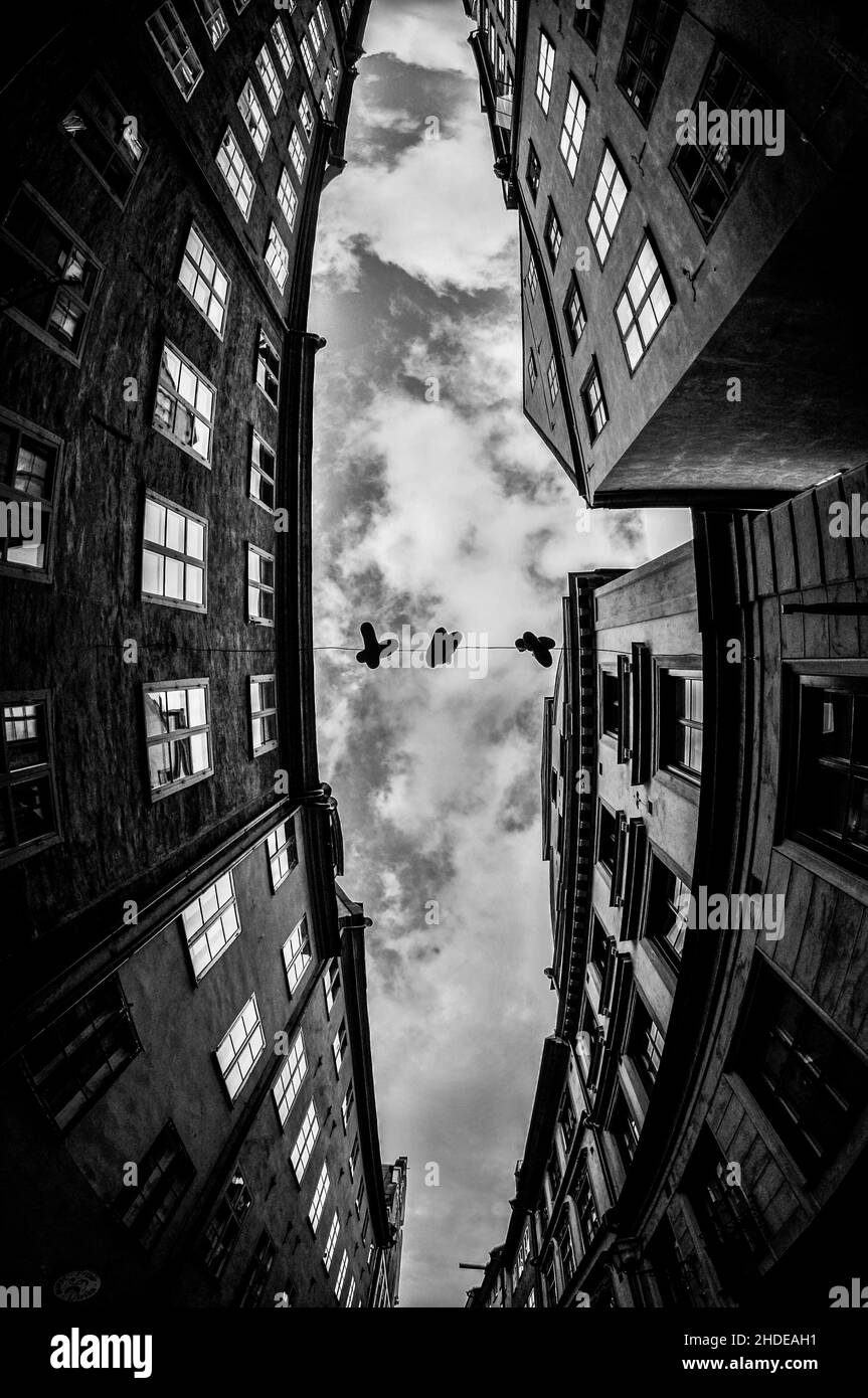 Grayscale low angle Dramatic scene with clouds and facade of buildings ...