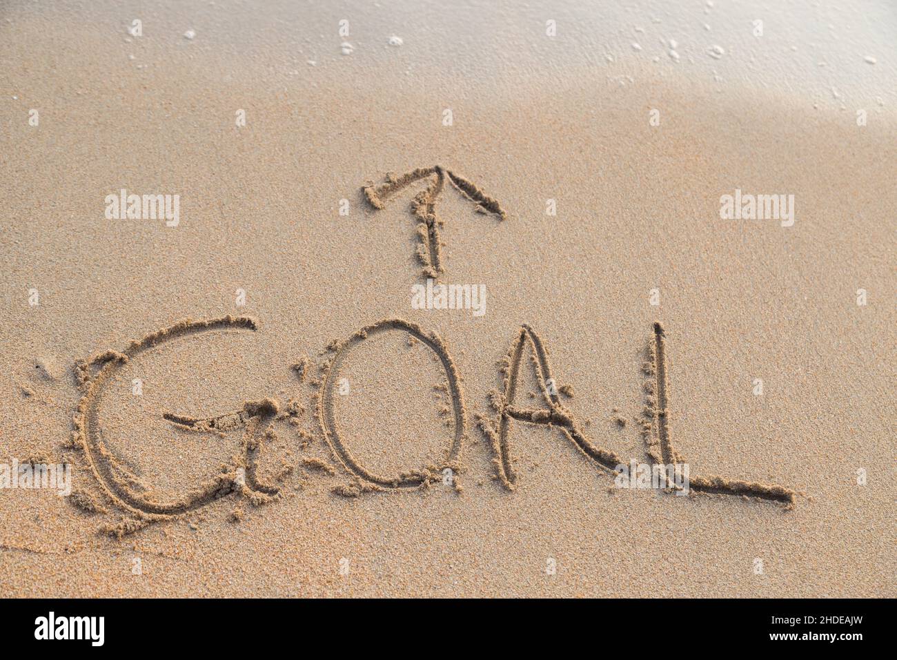 Message goal on the sand with upper arrow on sand at the beach ...