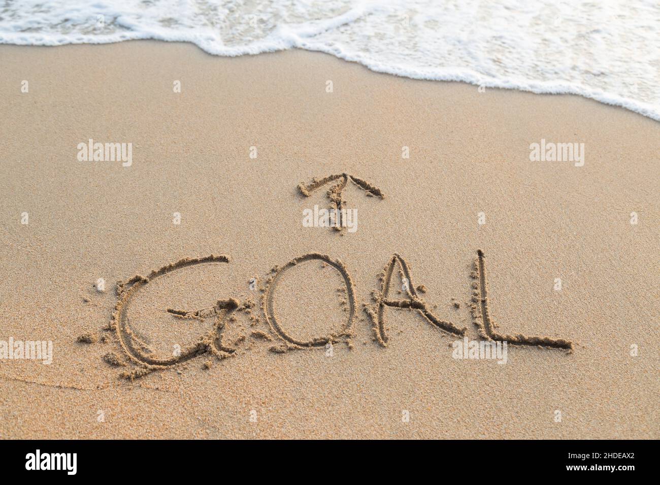 Message goal on the sand with upper arrow on sand at the beach ...