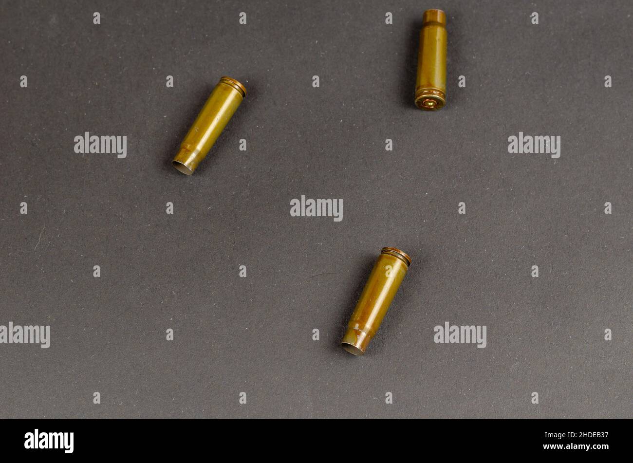 Three empty automatic rifle cartridges on a black background. Close-up ...