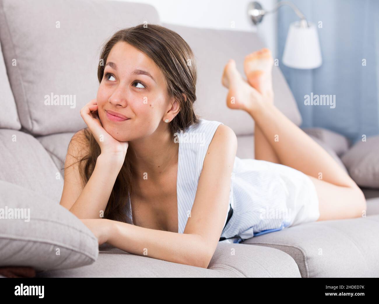 Female is posing on sofa Stock Photo - Alamy