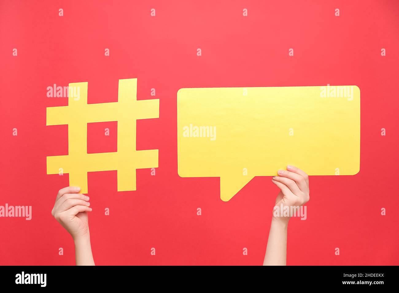 Female hands holding yellow paper hashtag symbol and speech bubble ...