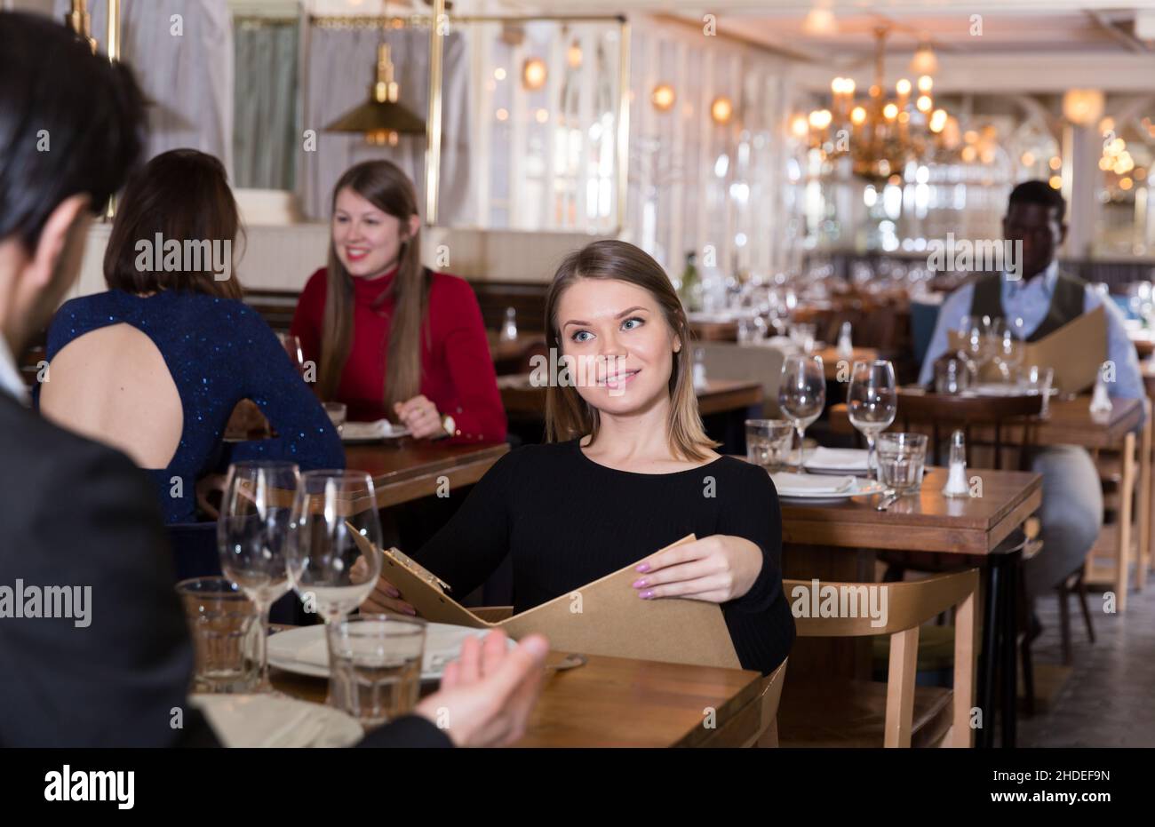 Girl with boyfriend choosing meal from menu Stock Photo - Alamy