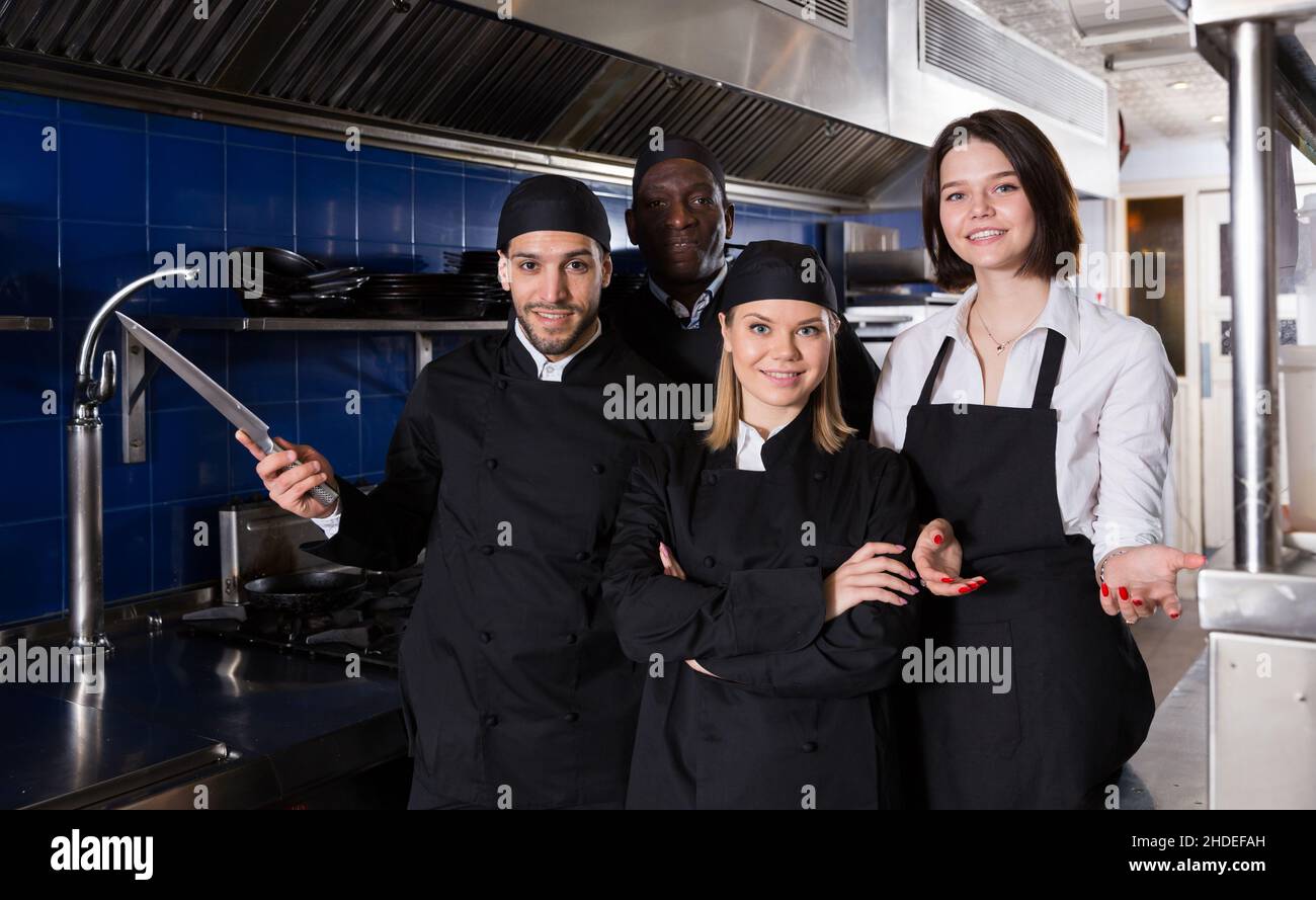 Woman waiter with kitcheners are standing together on kitchen Stock ...
