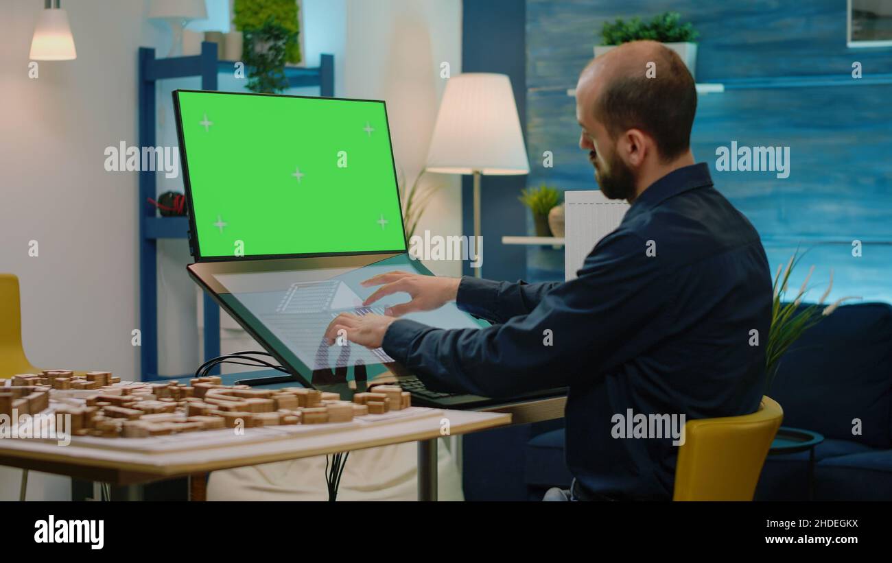 Architect using horizontal green screen and building model working on ...