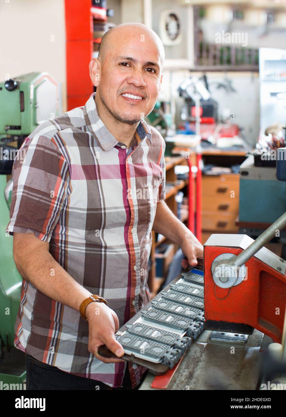 Smiling senior man doing vehicle numbers on machine Stock Photo - Alamy