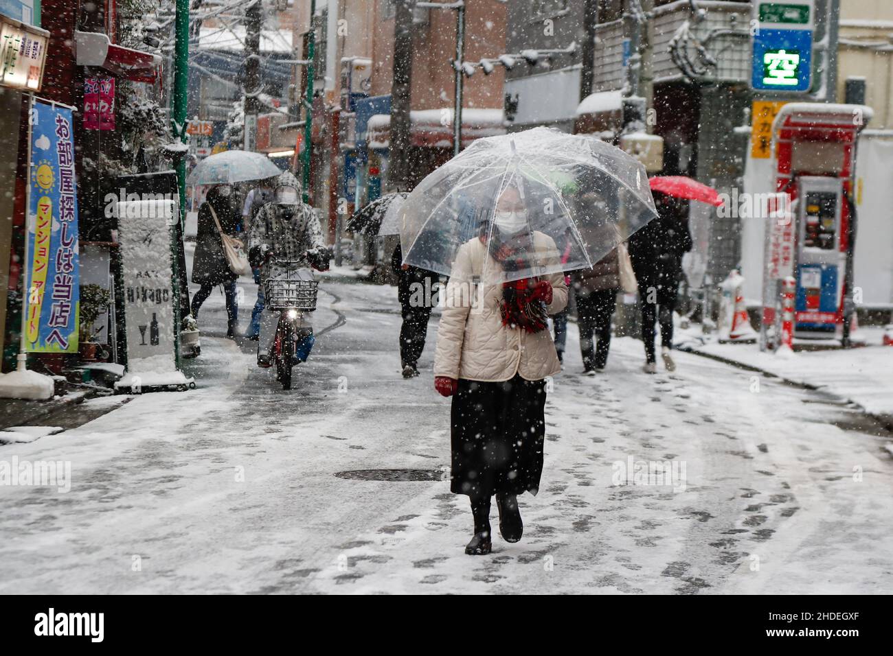 Tokyo, Japan. 6th Jan, 2022. A woman walks in the falling snow in Tokyo ...