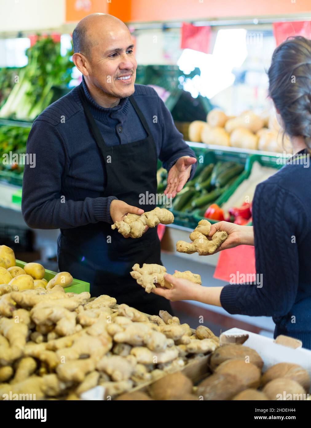 man helping customer to choose ginger Stock Photo - Alamy