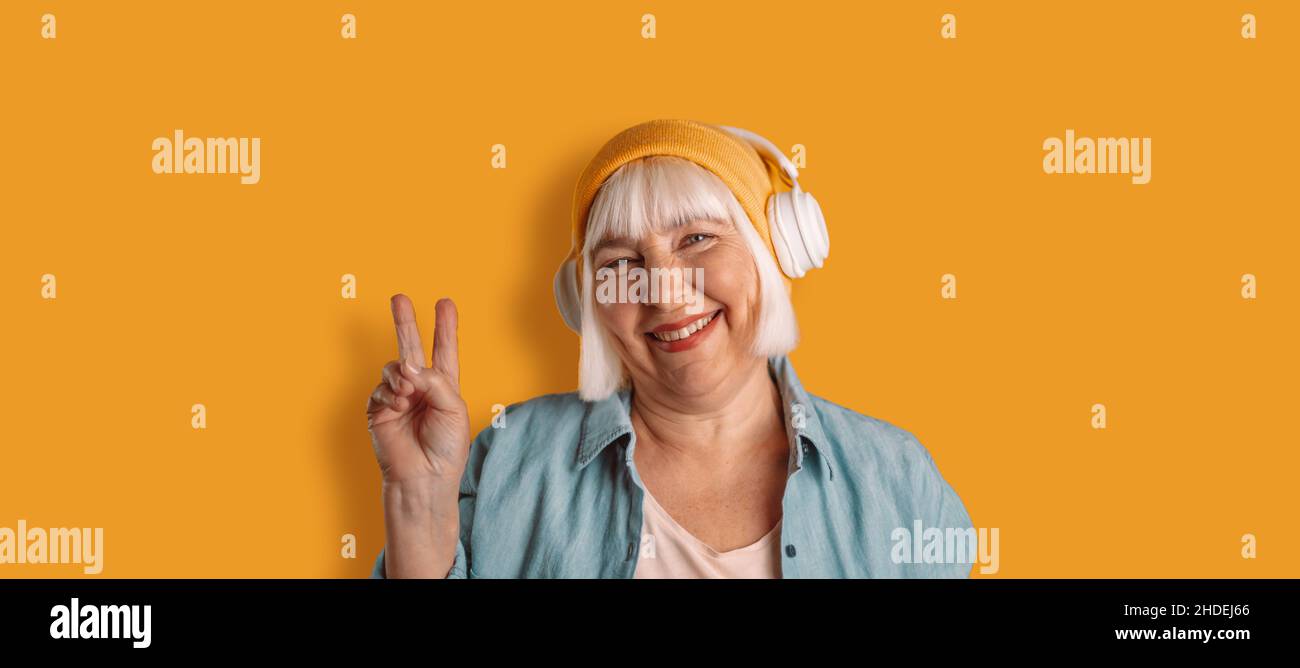 Happy 50s woman listens music expresses sincere emotions being in good ...