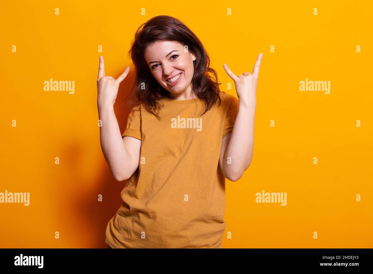 Portrait of joyful woman showing rock symbol with hands to have fun ...