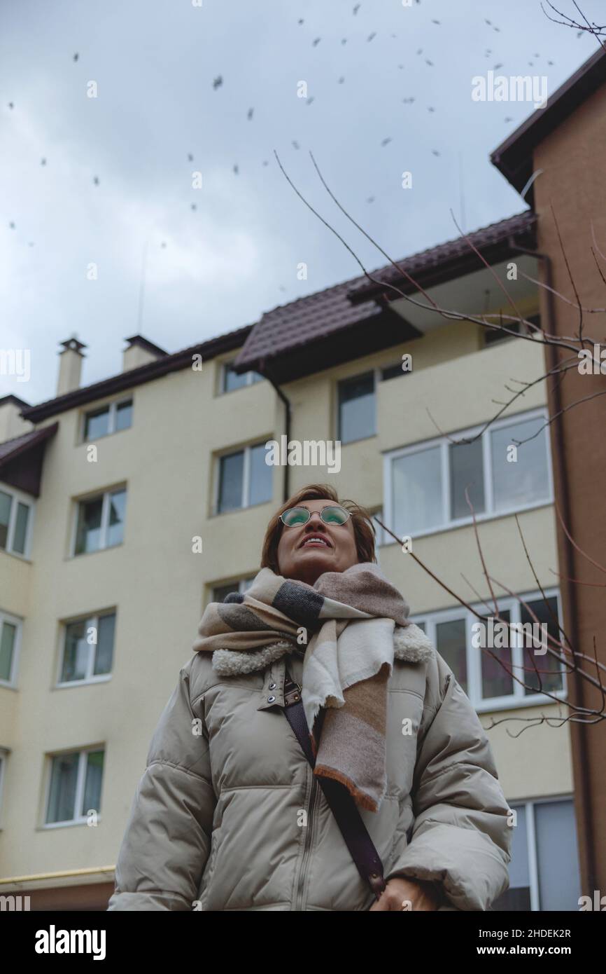 Beautiful baby boomer woman of middle age in glasses and stylish casual ...