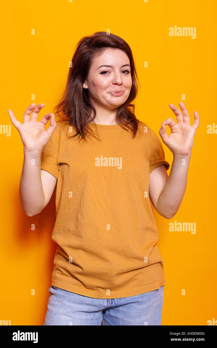 Optimistic woman doing approval symbol on camera. Caucasian person ...