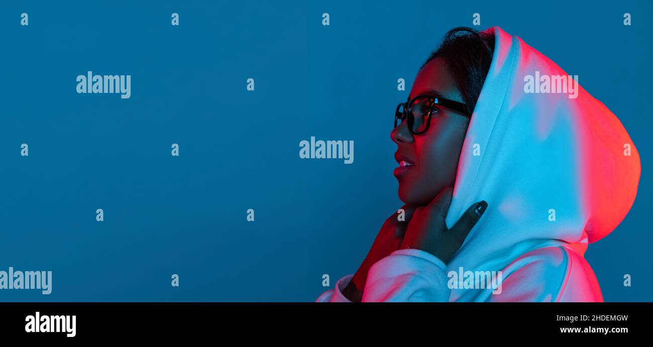 Profile view of young beautiful girl in hoodie posing isolated on ...