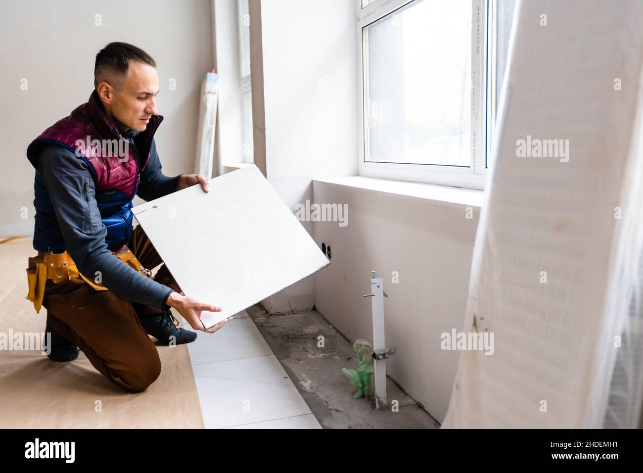 industrial tiler builder worker installing floor tile at repair ...