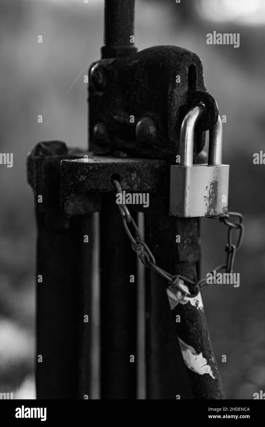 Closeup black and white picture of a lock with a chain of a railroad ...