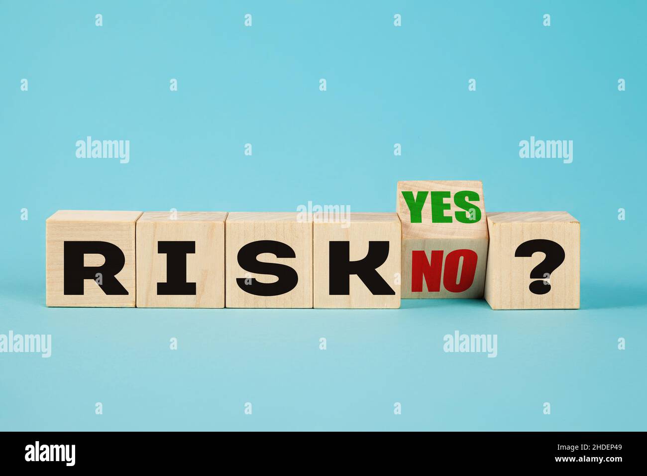 Risk symbol. A wooden cube with the word risk yes or no representing ...