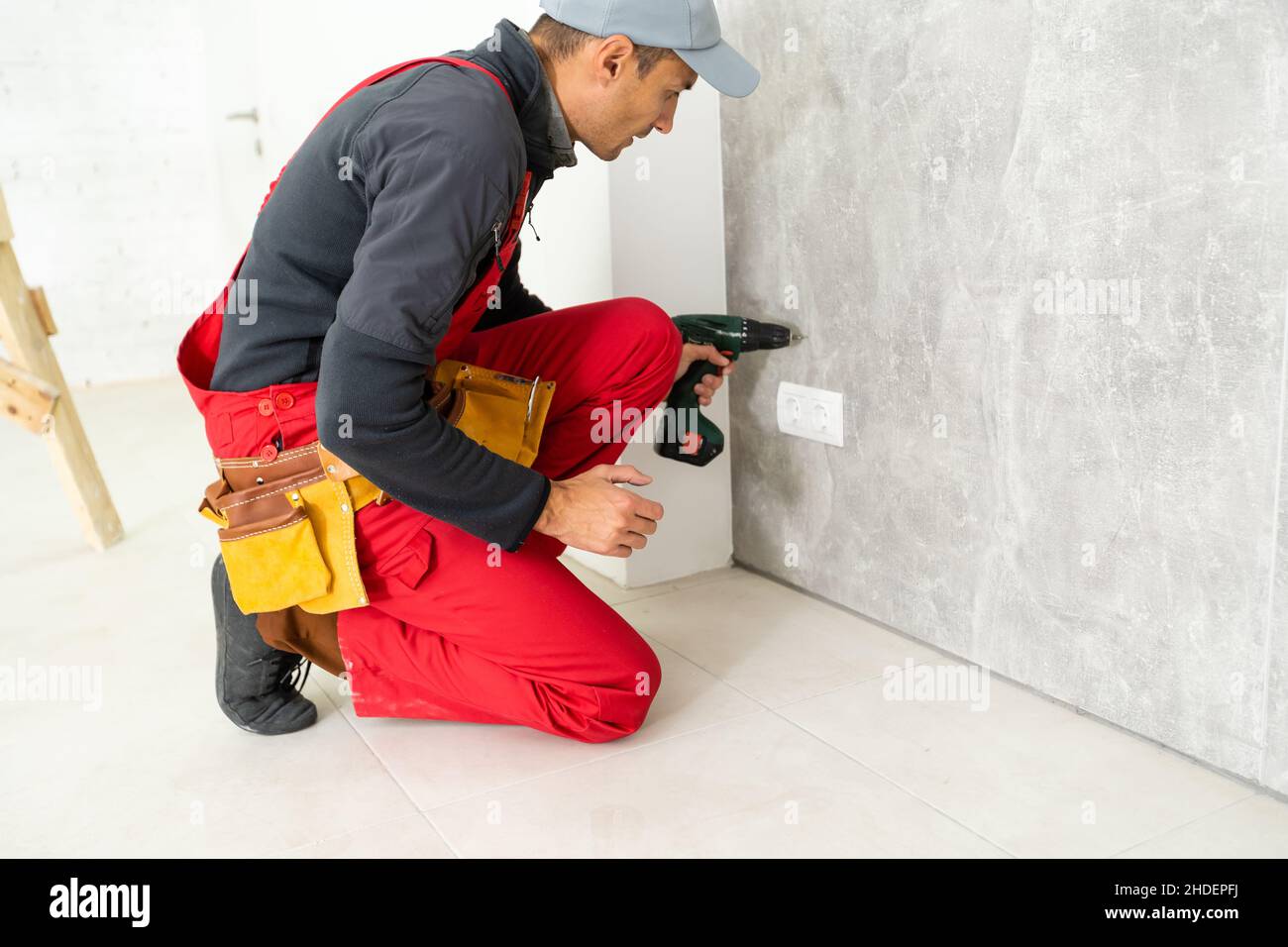 Electrician working at plug socket in the building Stock Photo - Alamy