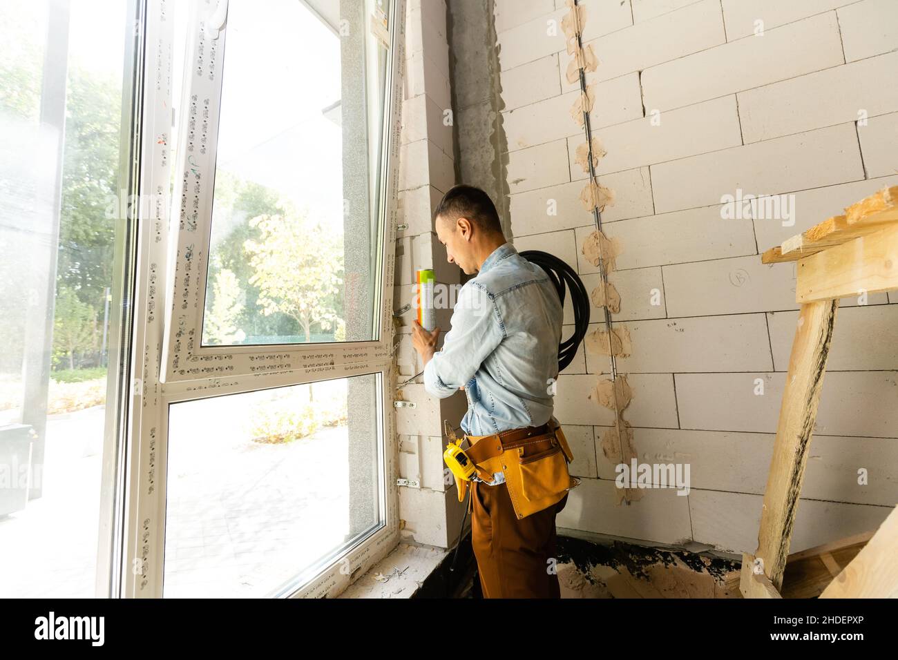 Construction worker installing window in house Stock Photo - Alamy