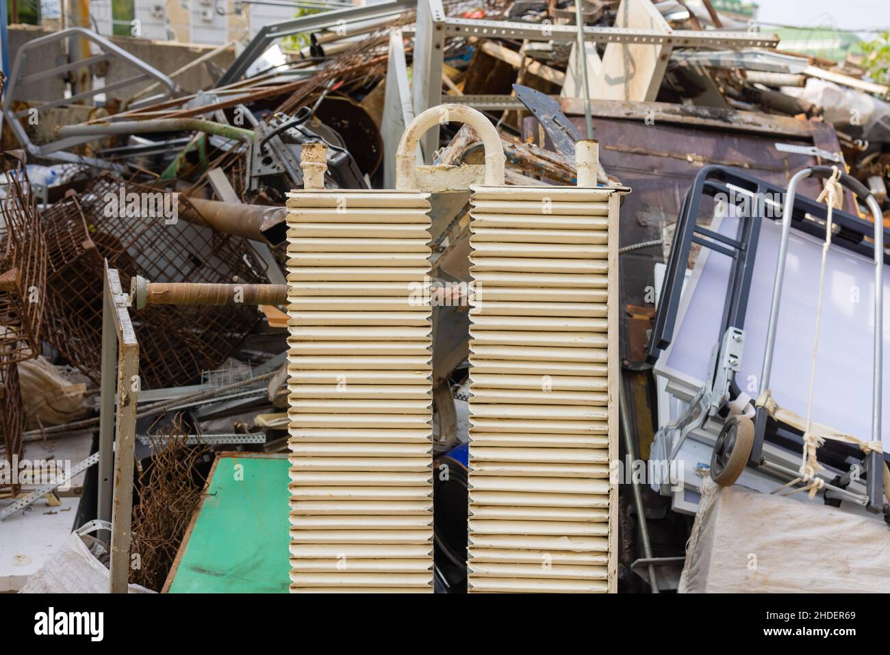 Multi colored cast iron radiators, old heating elements stacked in heap ...