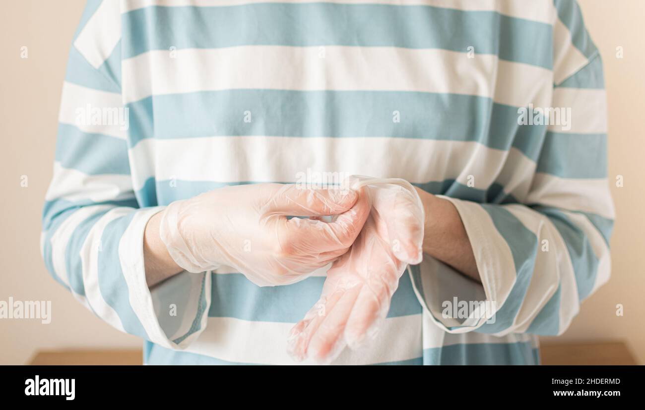 Woman starting to take off transparent vinyl gloves Stock Photo - Alamy