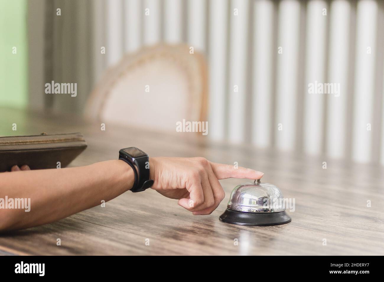 Woman hand pressing a hotel service bell at reception counter Stock ...