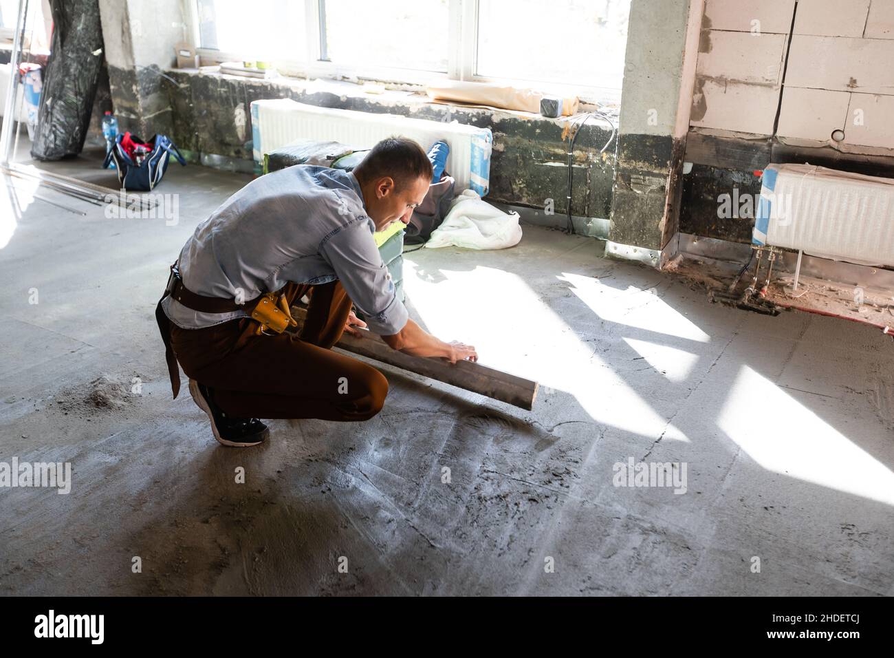 Smiling Builder repairman worker in dirty workwear at construction site ...