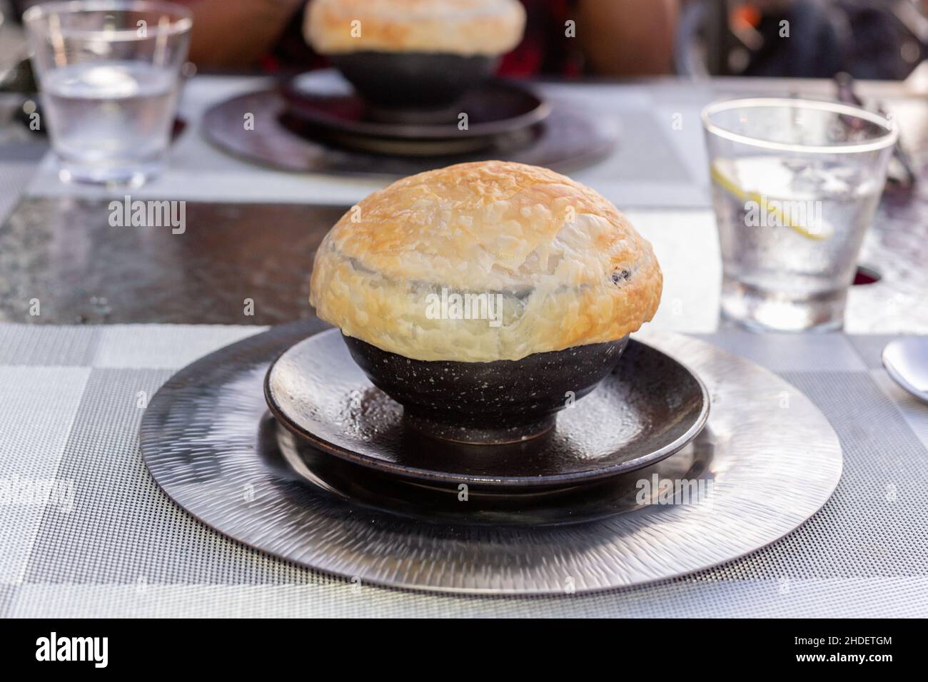 Clay pot under the bread lid hot vegetable soup served in a restaurant ...