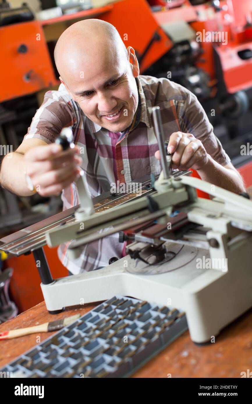 Workman making mailbox plate in workshop Stock Photo - Alamy