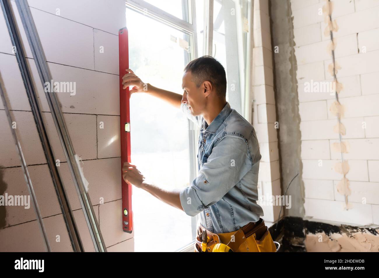 Construction worker installing window in house Stock Photo - Alamy