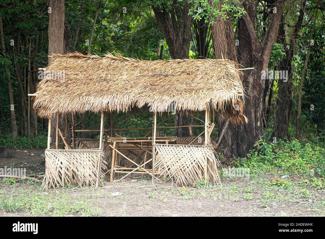 A straw hut without walls on the edge of the jungle. Selective focus ...