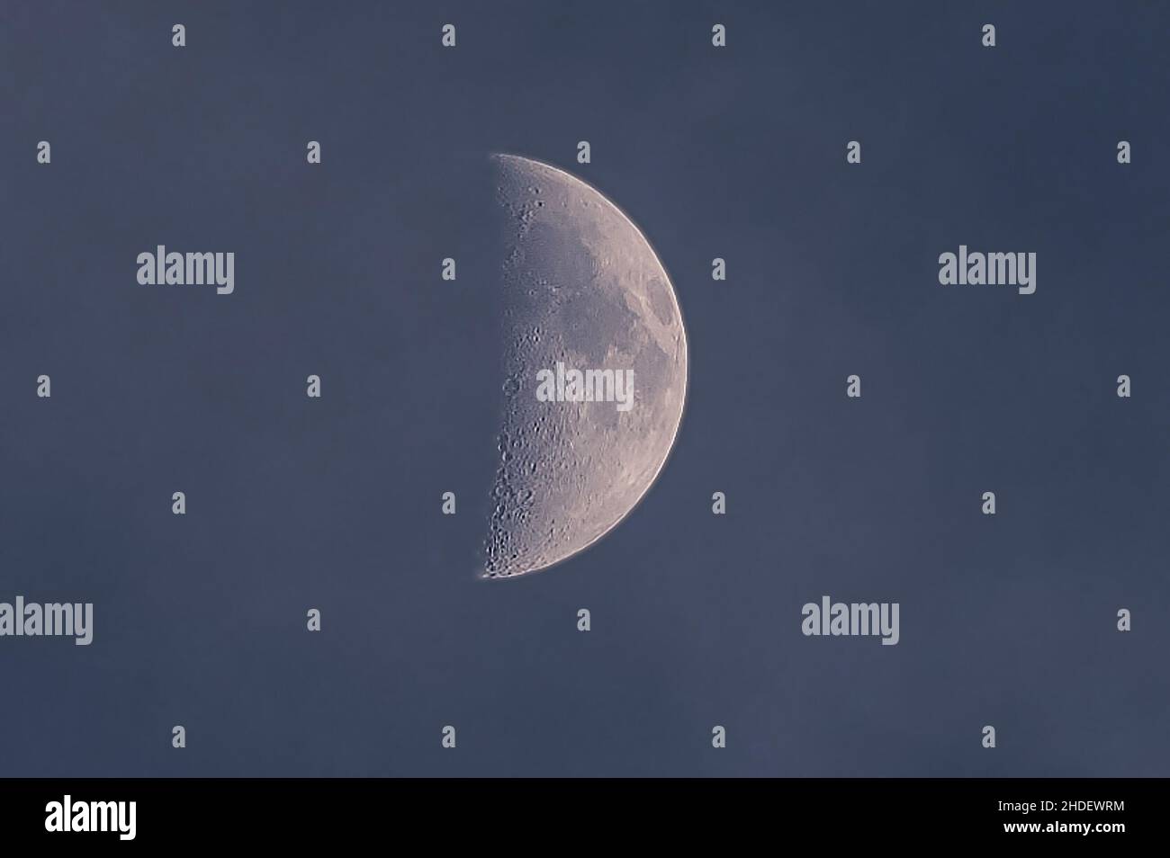 Half moon during the first quarter phase isolated against a black sky ...