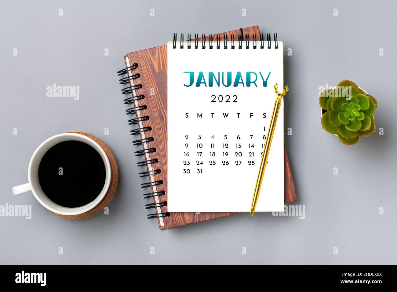Open calendar January 2022, cup of coffee, pen on gray background Top ...