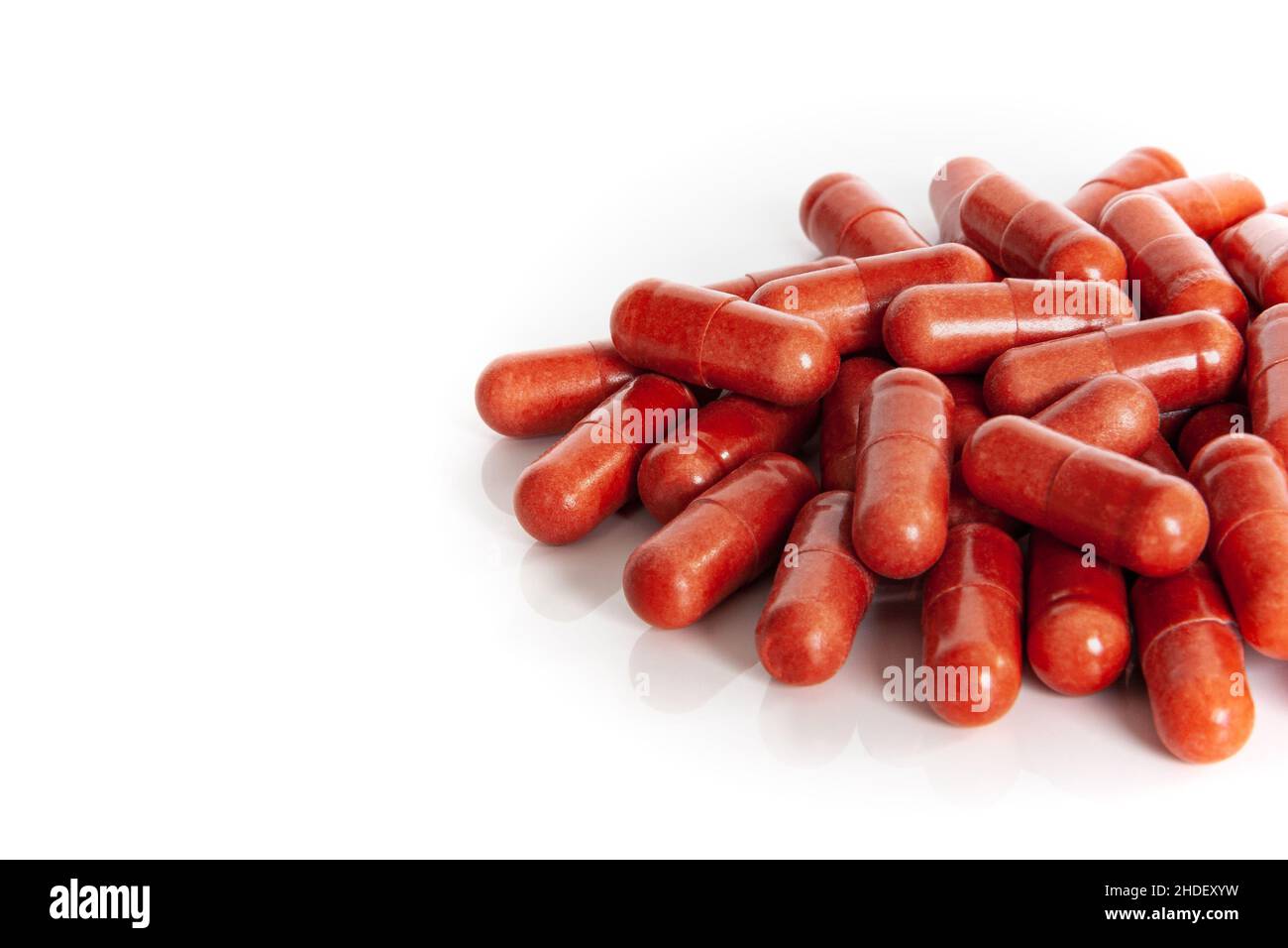 Front view detail of red vitamin supplements isolated on a white ...