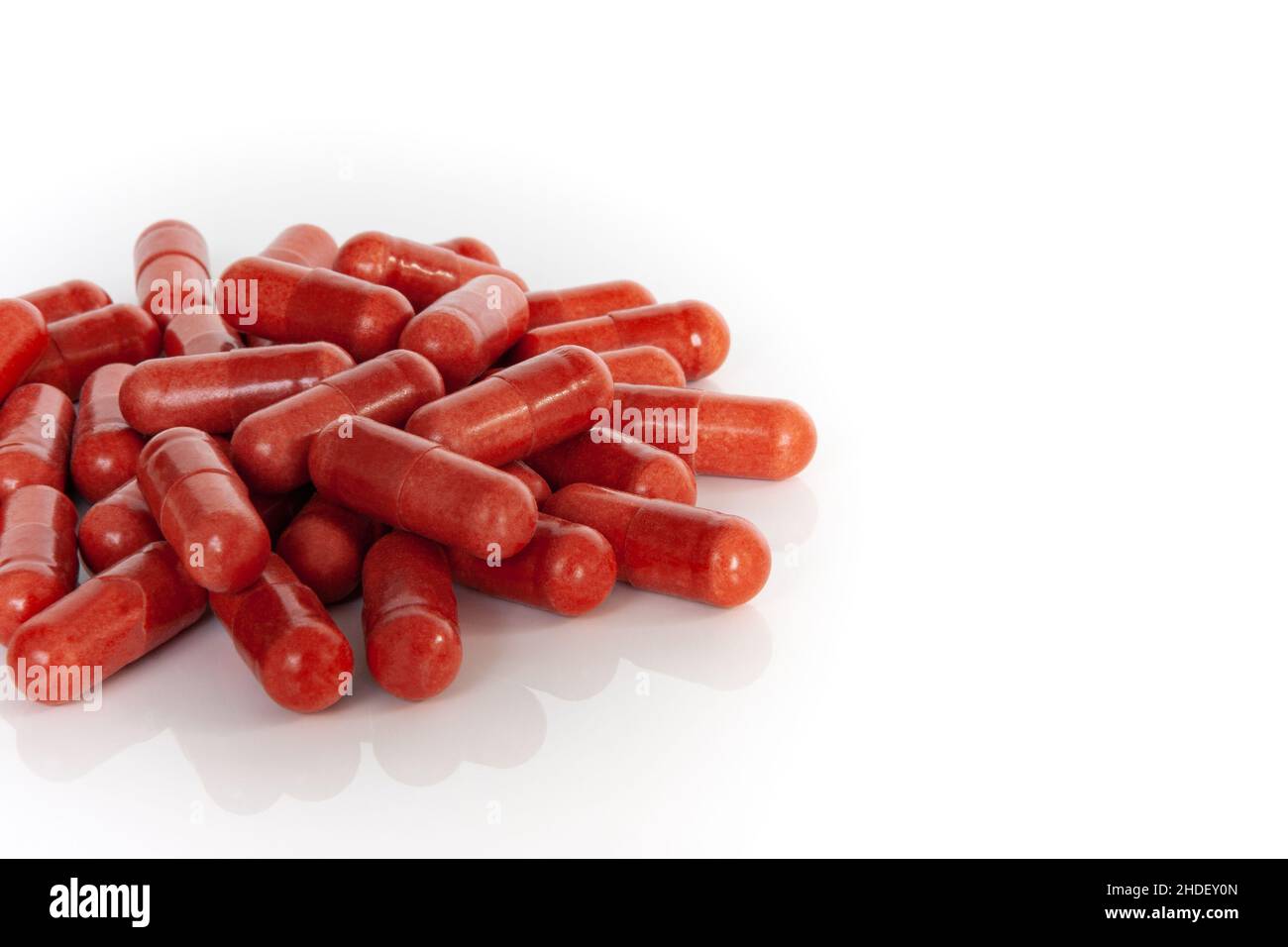 Front view detail of red vitamin tablets isolated on a white background ...