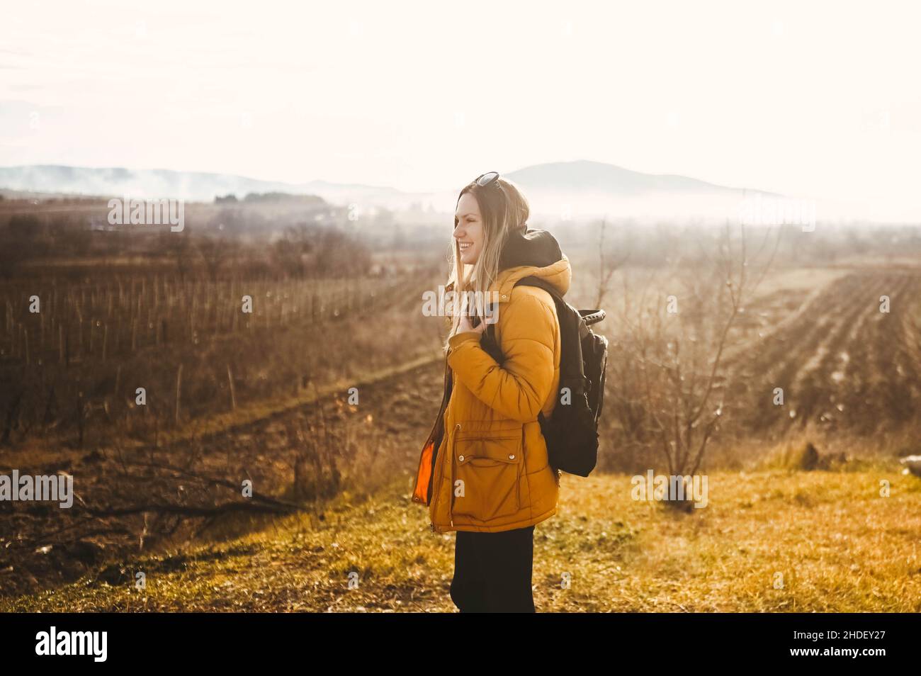 Young happy backpacker woman tourist traveling alone and posing at dawn ...
