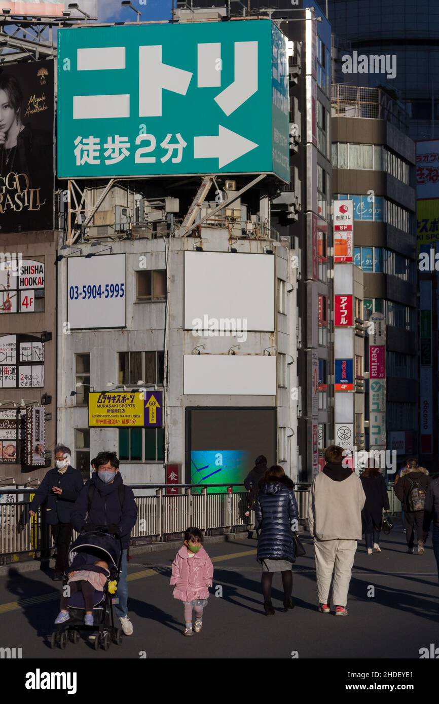 People, wearing surgical face masks against COVID-19, walk in Shinjuku ...