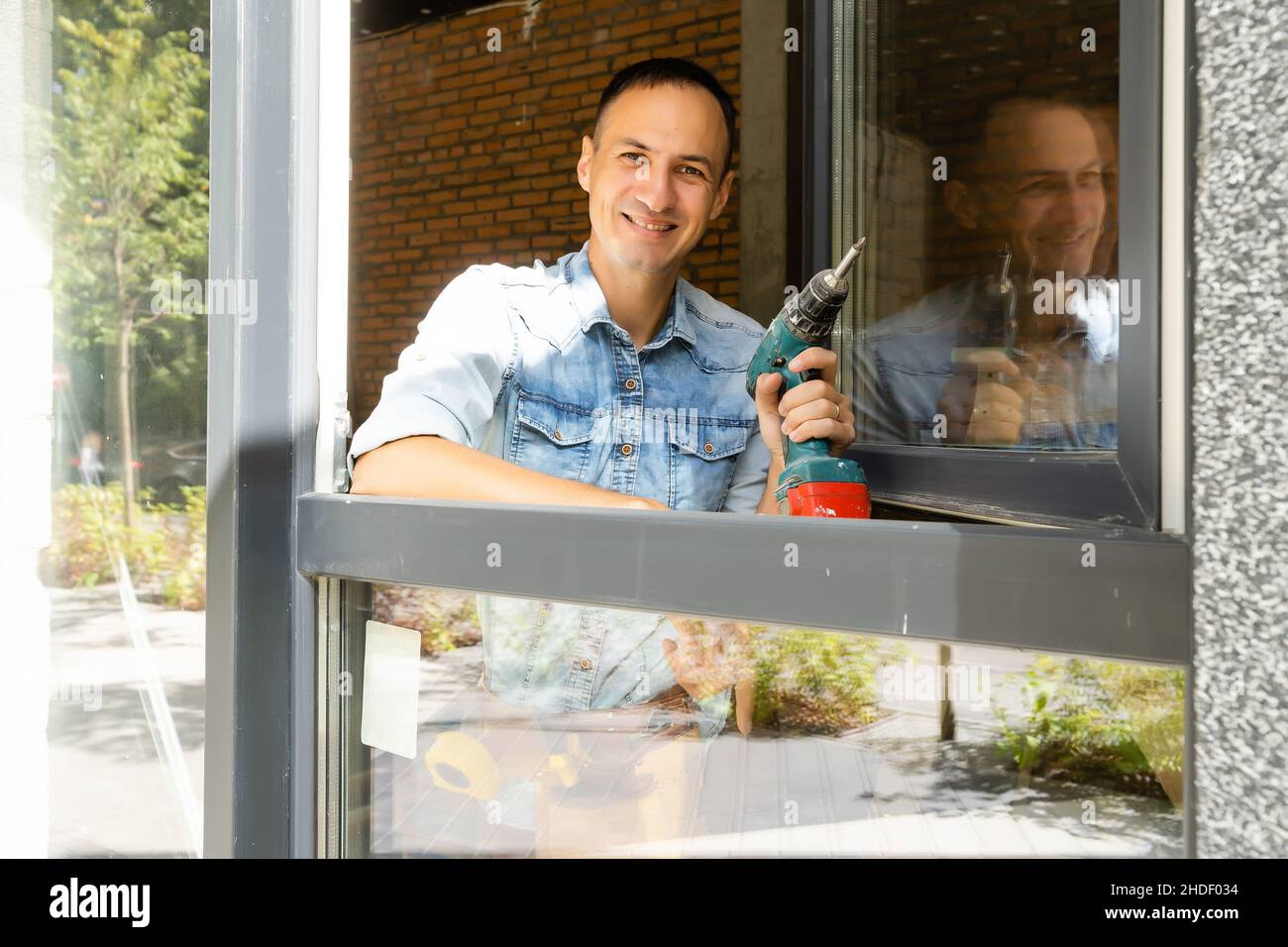 Construction worker installing window in house Stock Photo - Alamy