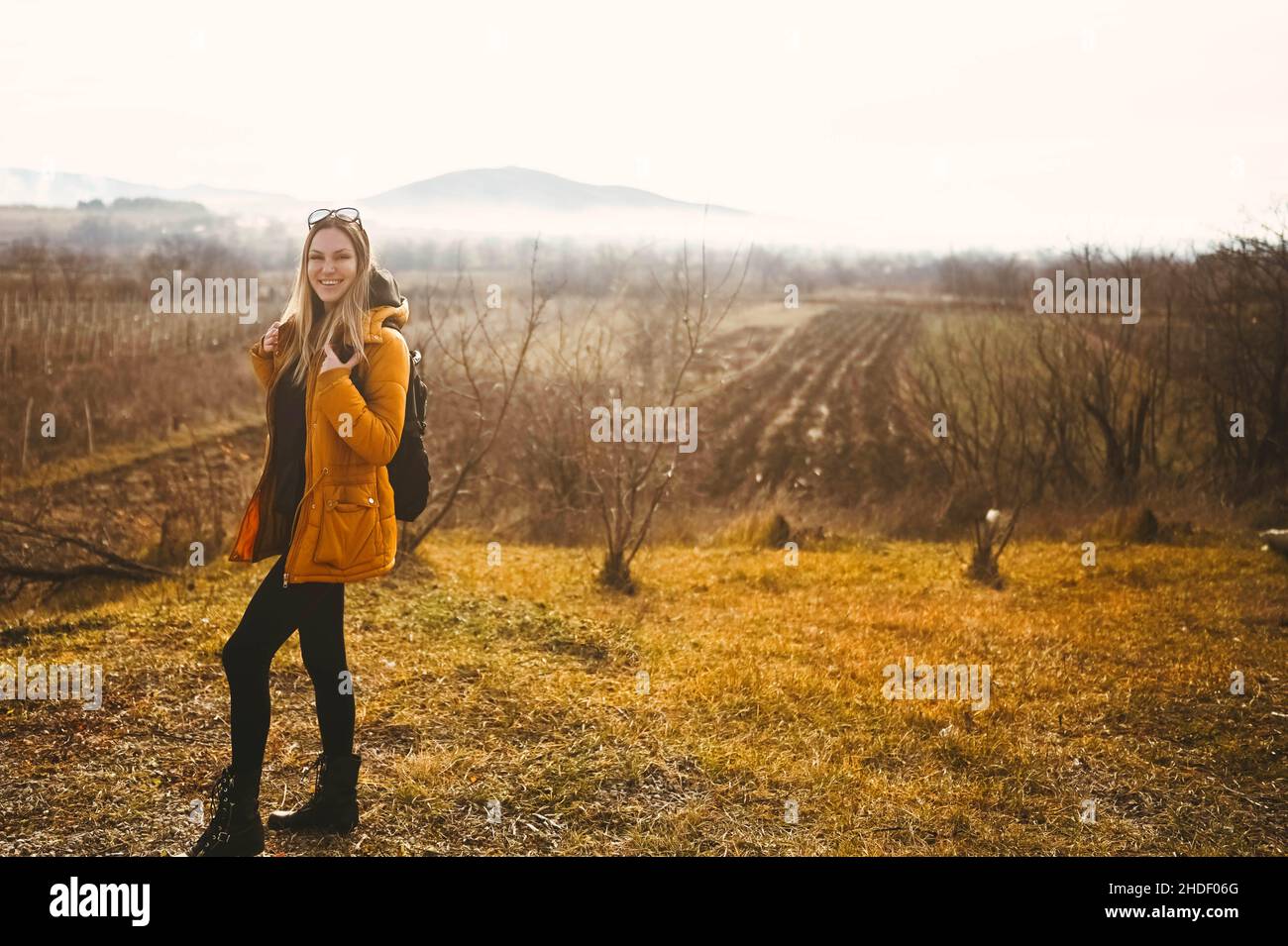 Young happy backpacker woman tourist traveling alone and posing at dawn ...
