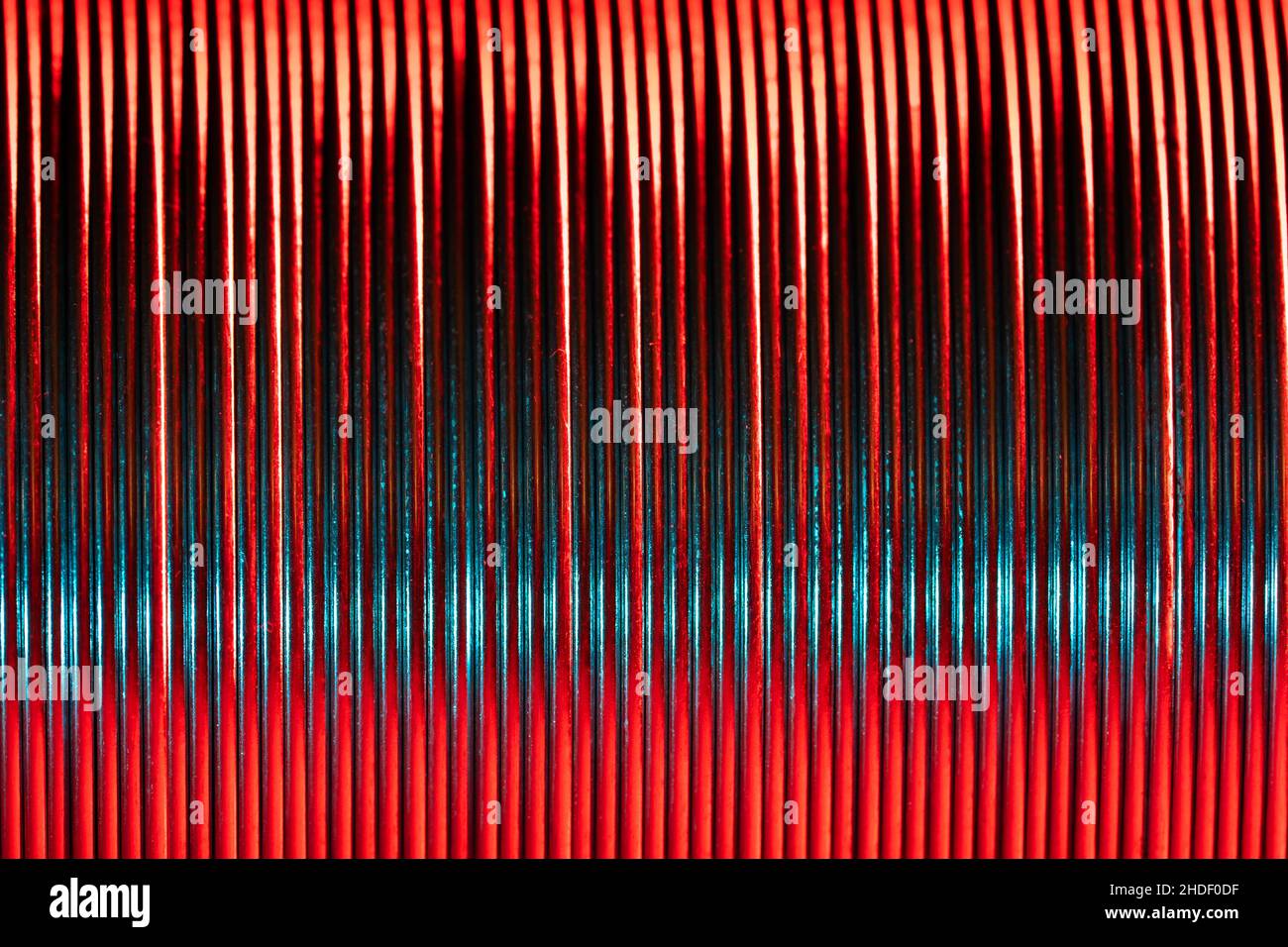 Closeup of coiled metal spring rings in a compressed state in red and ...