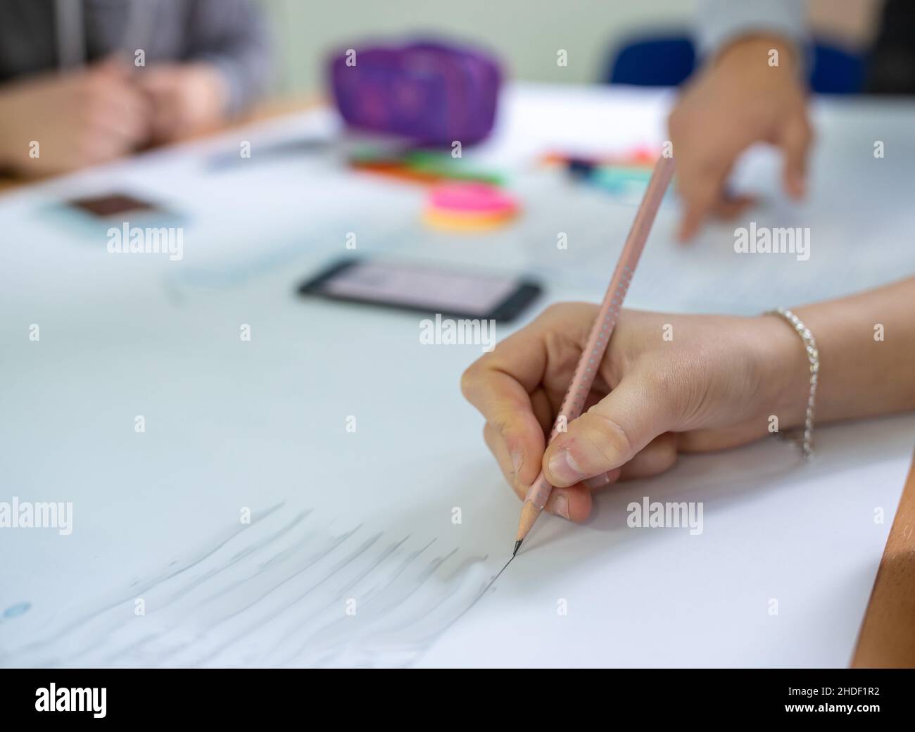 Close up of student's hand drawing and writing presentation on team ...