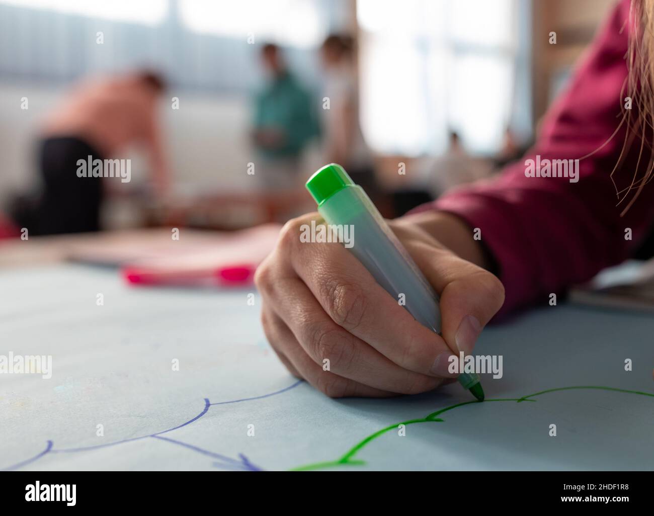 Close up of student's hand drawing and writing presentation on team ...