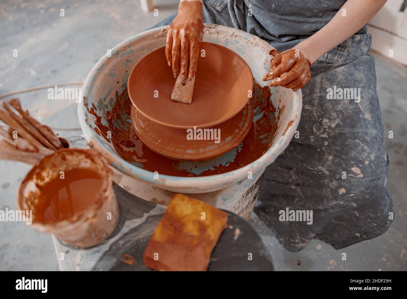 Handmade artist shaping clay bowl with instrument in art studio Stock ...