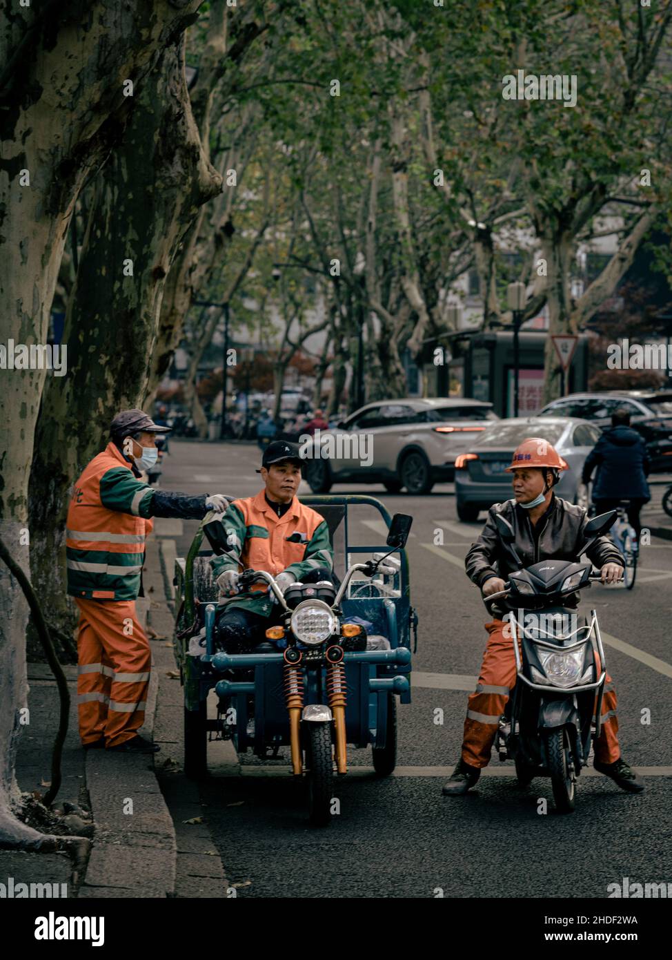 Vertical shot of construction workers on motorbikes in Hangzhou, China ...