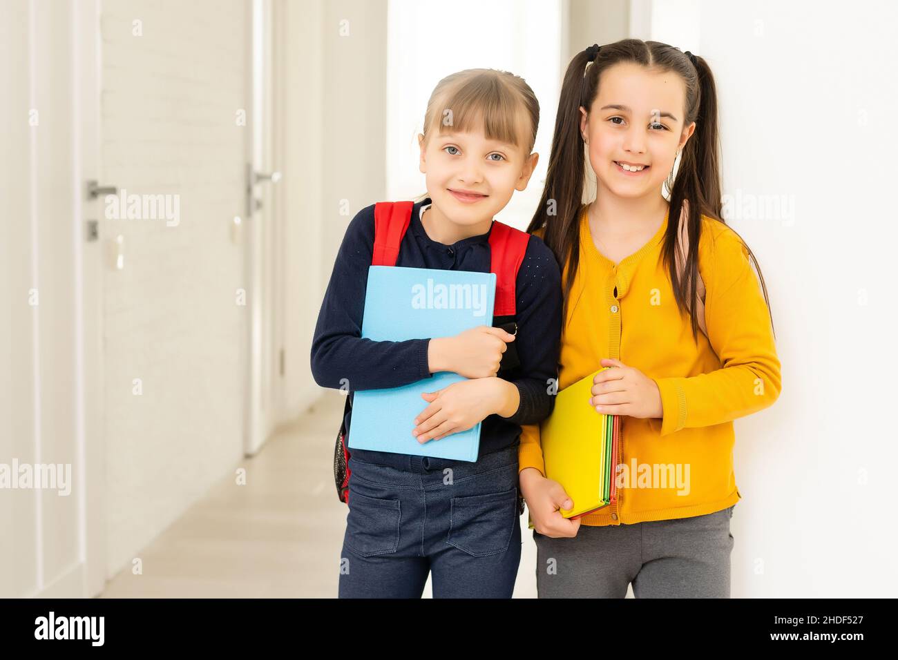 two pretty young schoolgirls. girls carry notebooks Stock Photo - Alamy