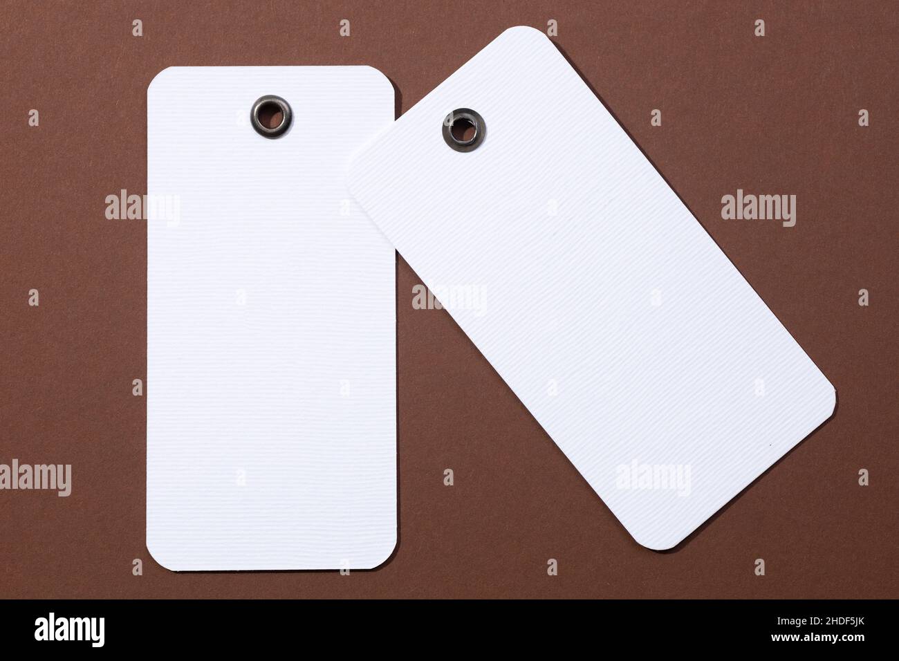 Cardboard blank white colored tags of rectangle shape with tiny holes ...