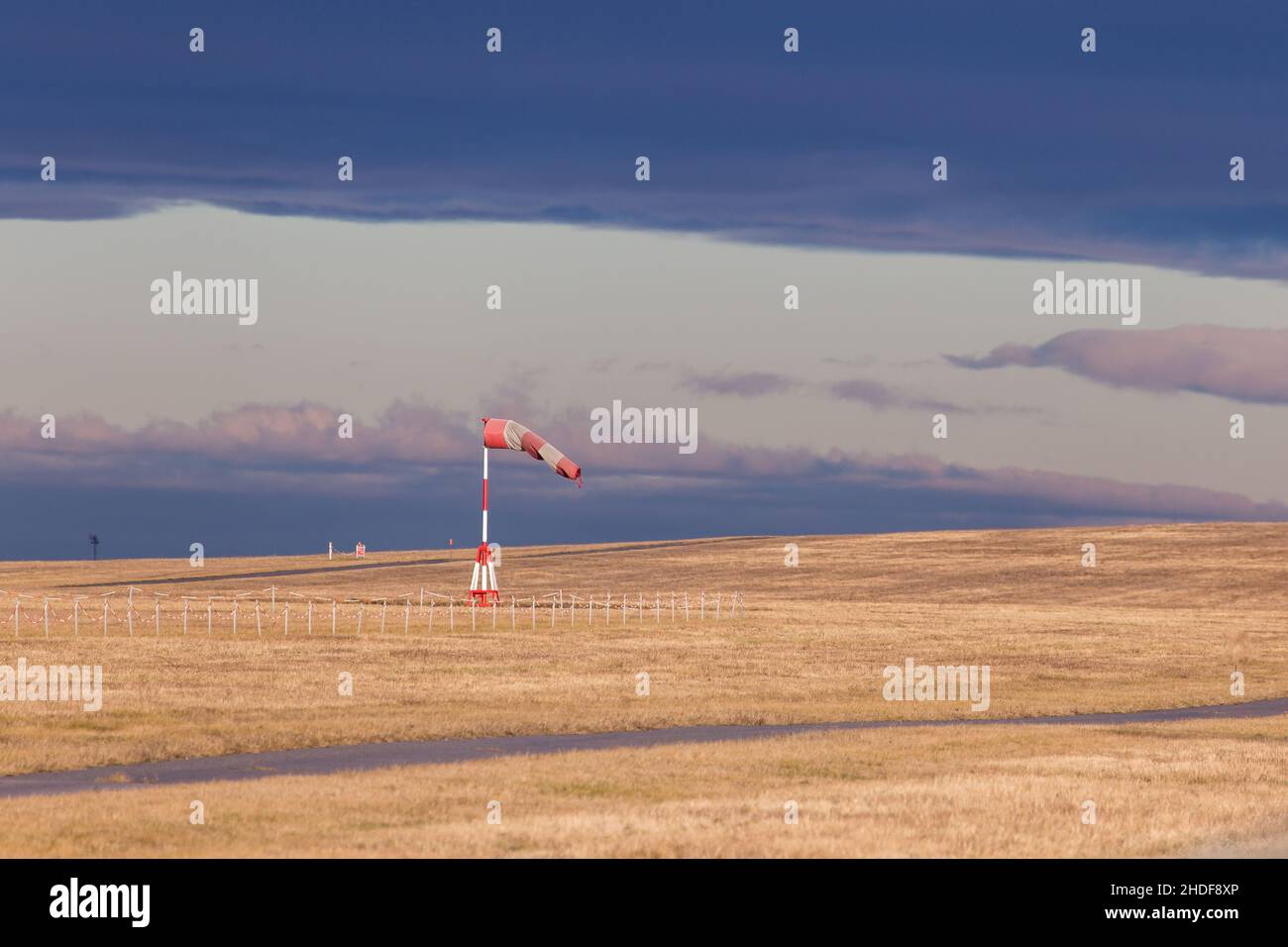 Windsock showing strong winds with dark clouds at an airport Stock ...
