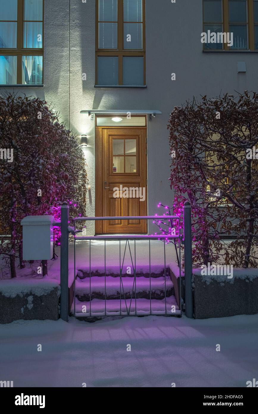 Snowy entrance gate of a house decorated with pink christmas lights ...